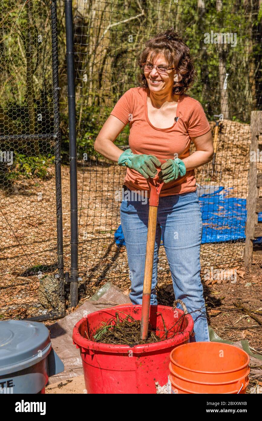 Woman mixing an equal mix of "greens" and "browns", with enough water ...