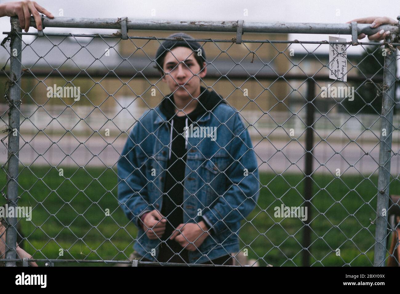 Boy behind fence Stock Photo - Alamy