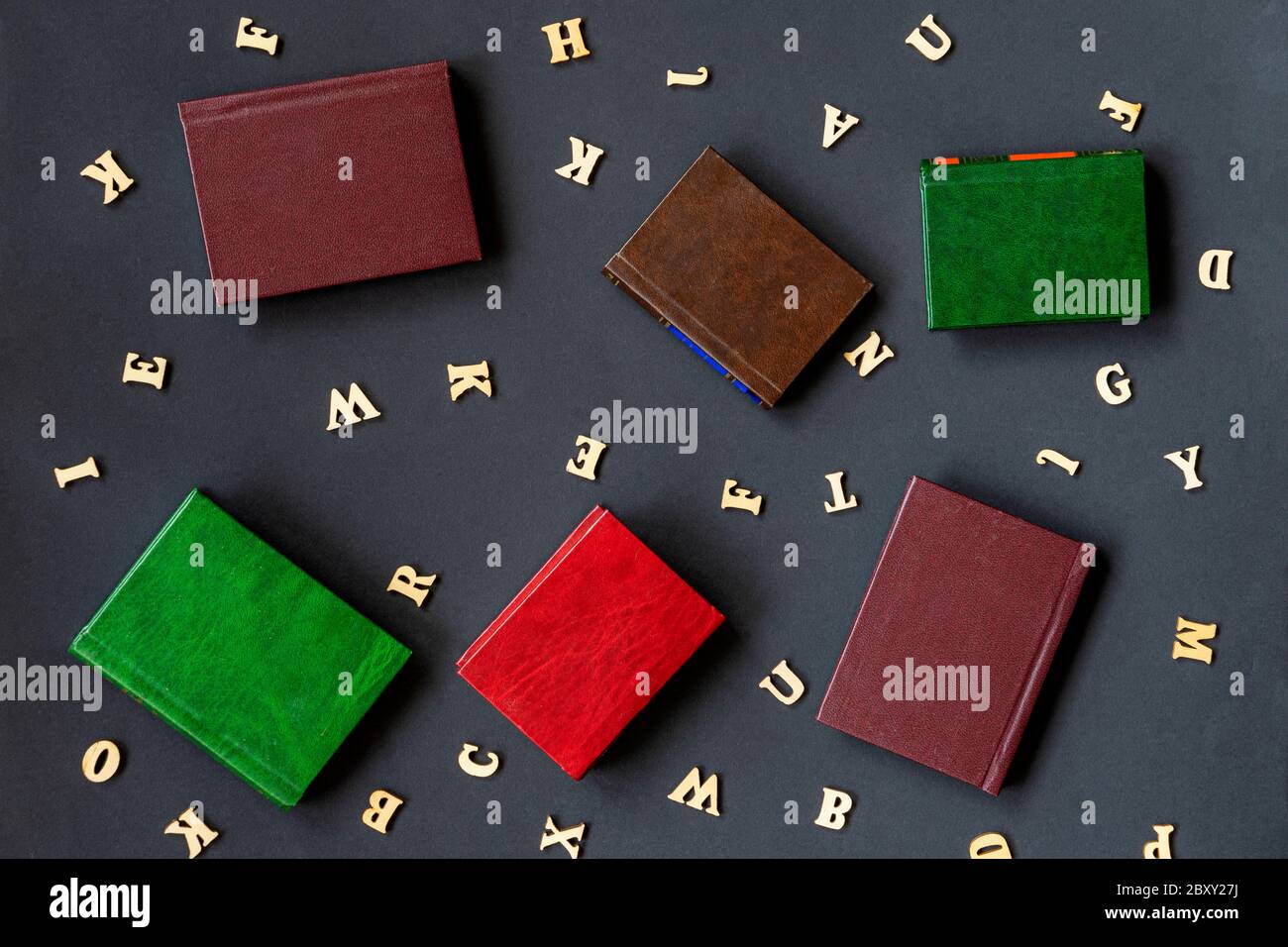 Several books and letters of the English alphabet on a dark background ...