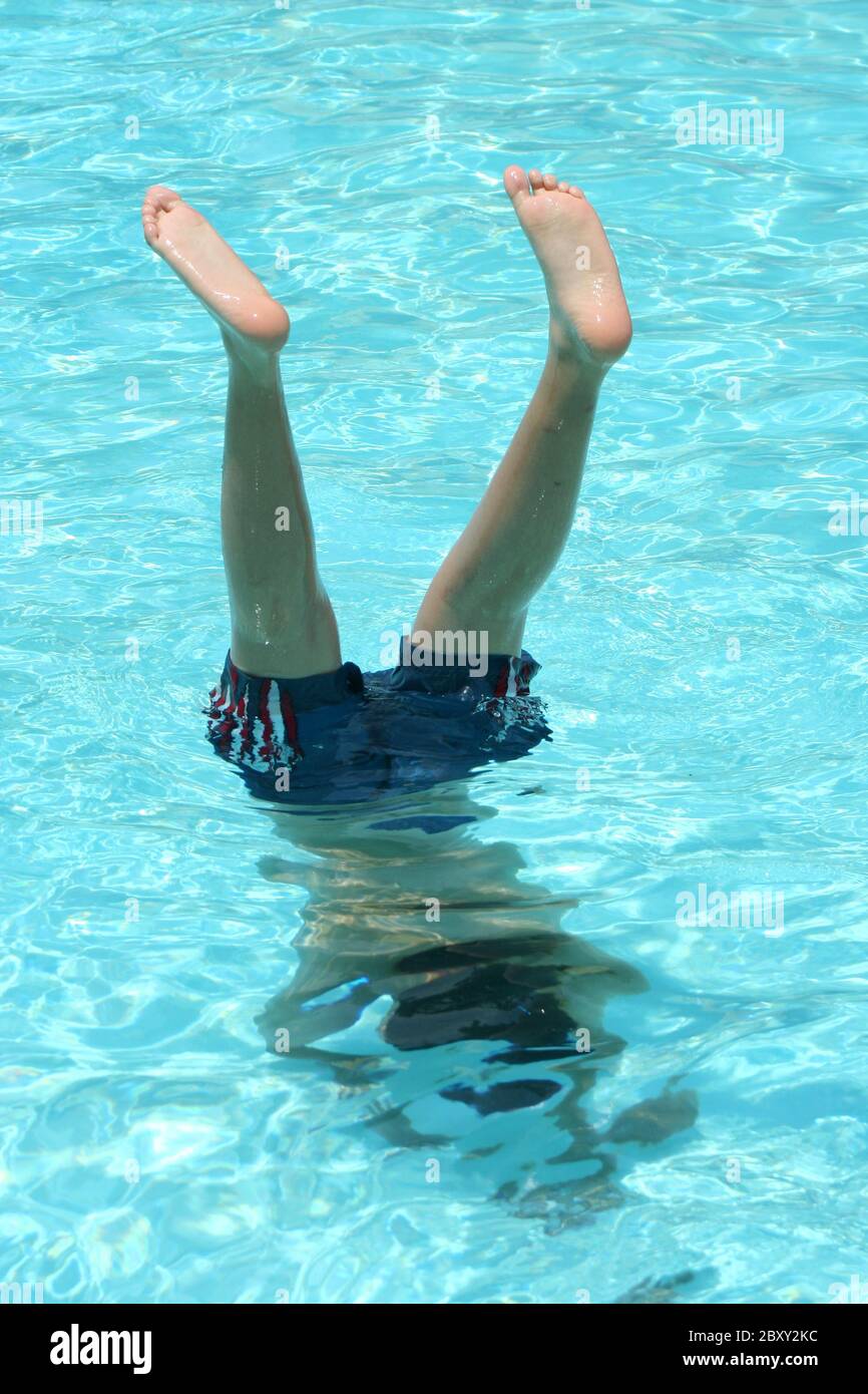 A Teenage boy doing a handstand in a pool Stock Photo - Alamy