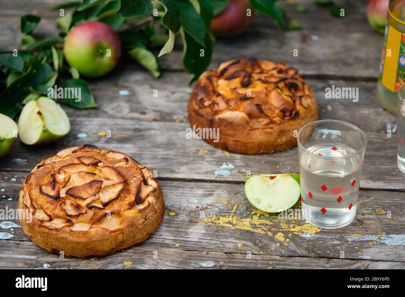Apple pies on an old wooden table under an apple tree in a village ...