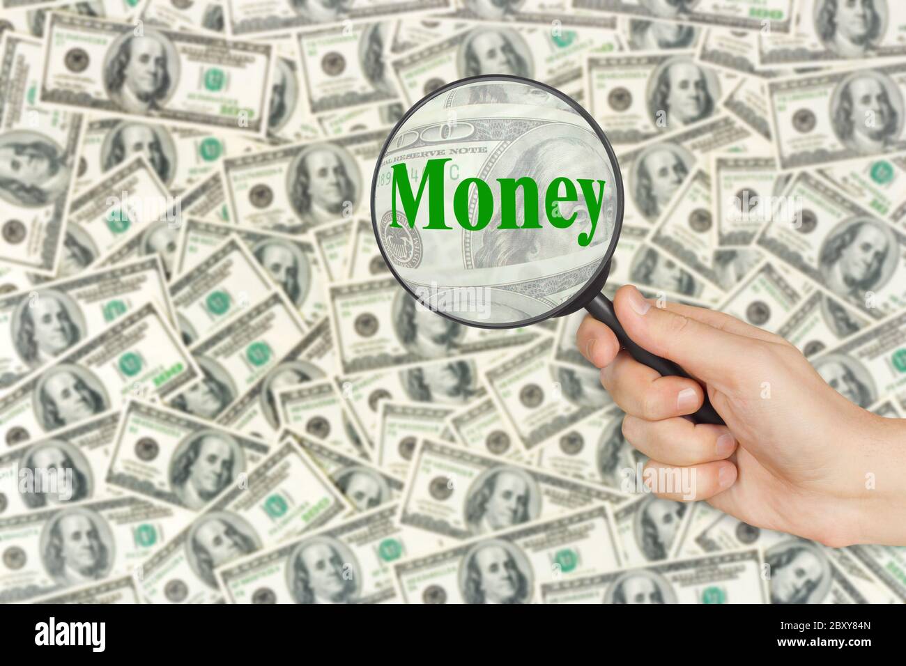 Money and magnifying glass in hand Stock Photo - Alamy