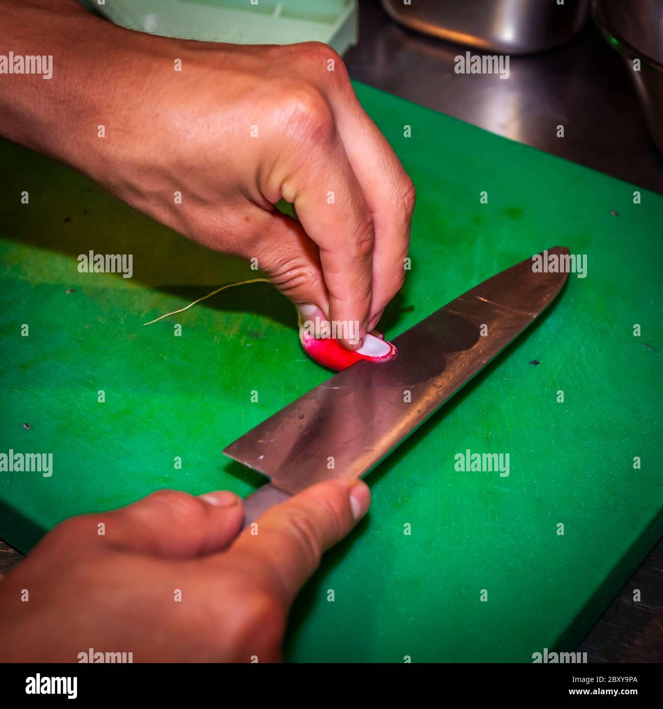 Finely slice a radish into large oval slices in Restaurant Lima in City ...