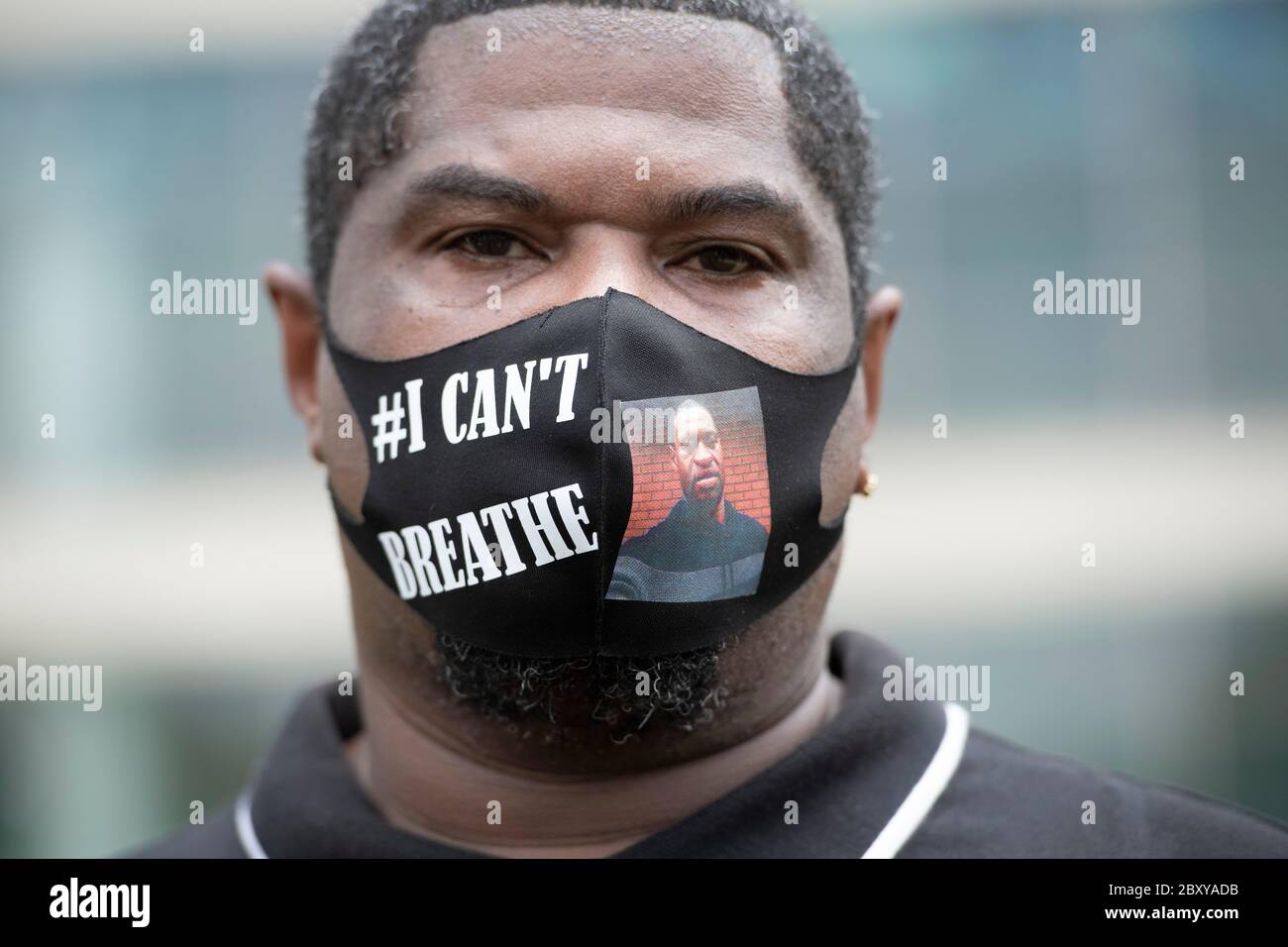 A man wearing a face mask with "I Can't Breathe" written on it and a ...