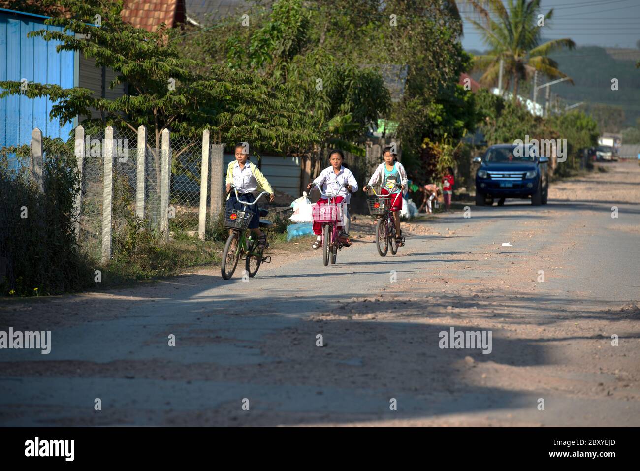 Three young girls riding their bicycles in the small, rural town of ...
