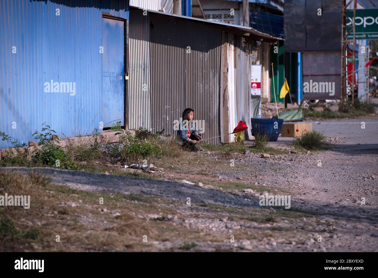 A young girl playing outside in the small, rural town of Muang Sing ...