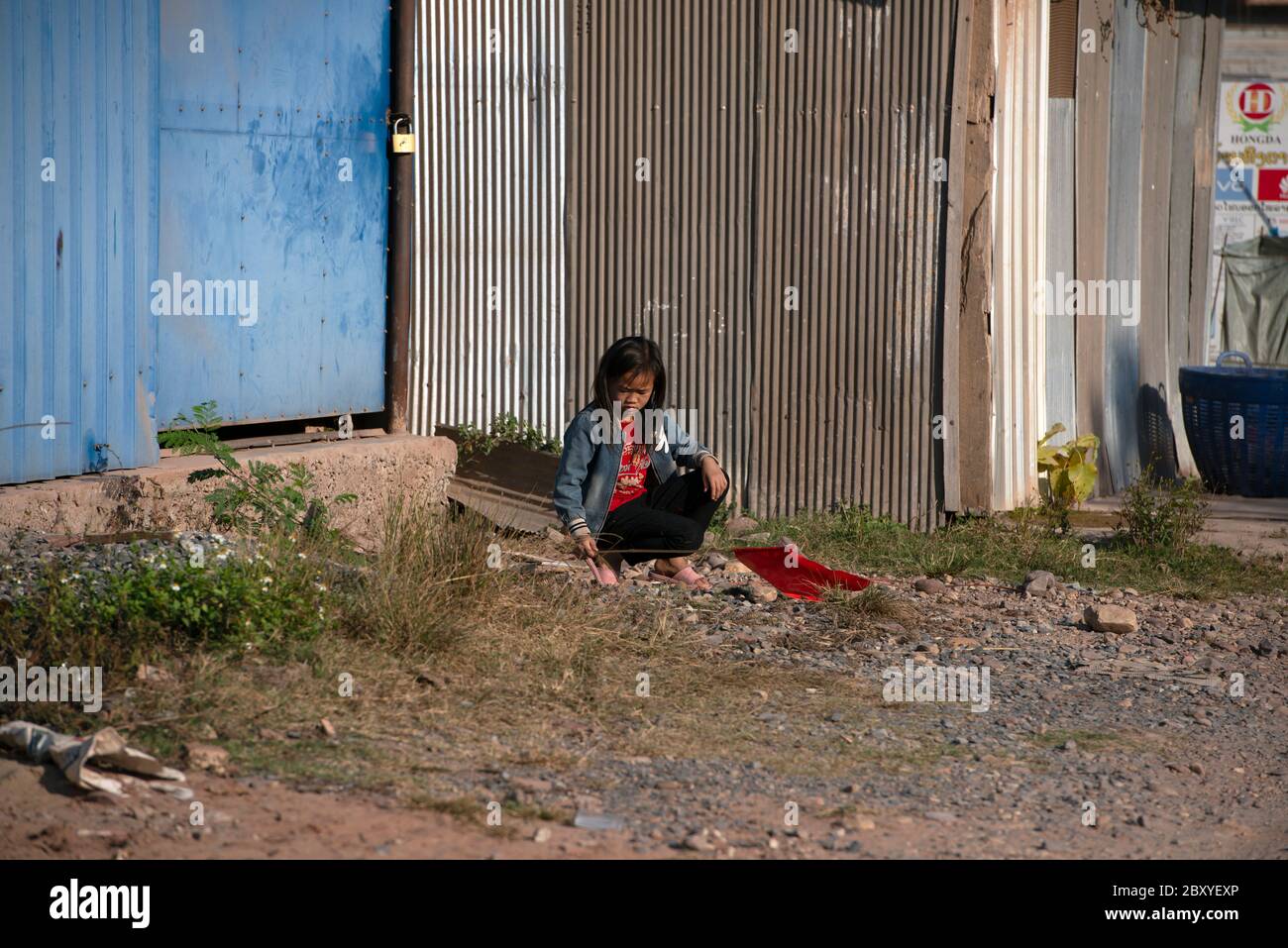 A young girl playing outside in the small, rural town of Muang Sing ...