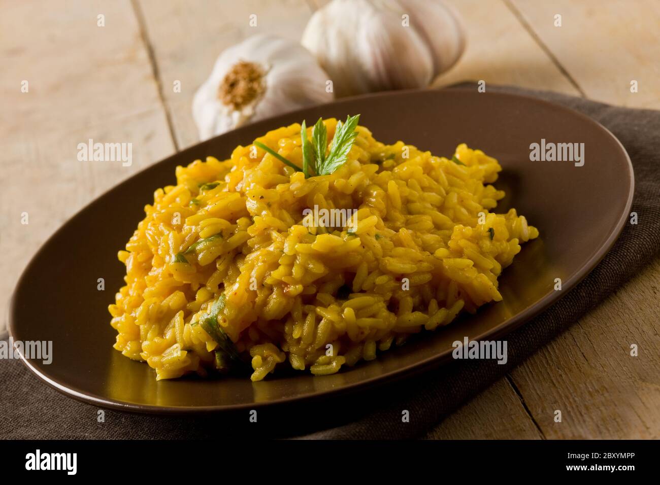 Risotto with Saffron on wooden table Stock Photo - Alamy