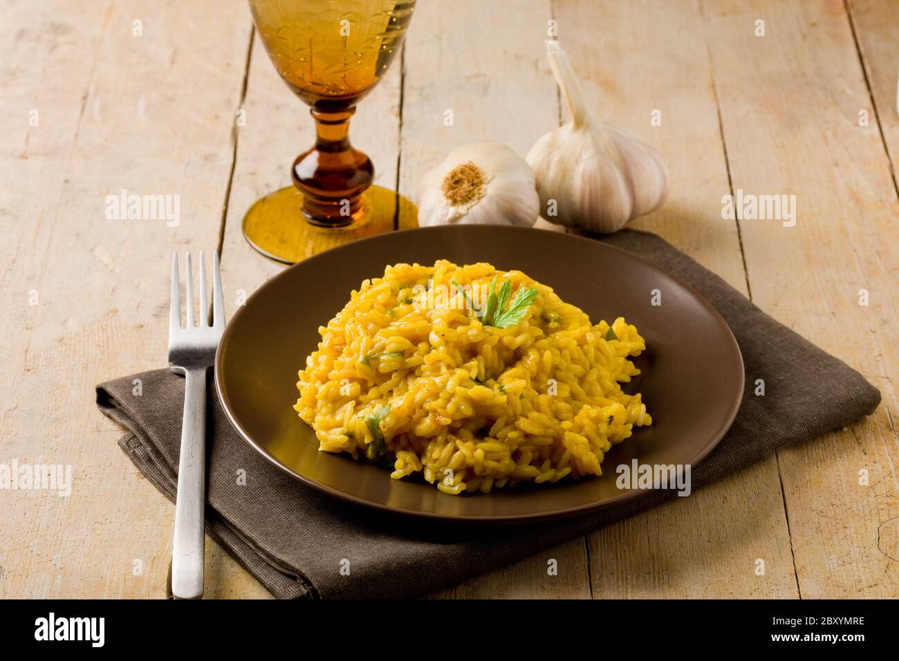 Risotto with Saffron on wooden table Stock Photo - Alamy