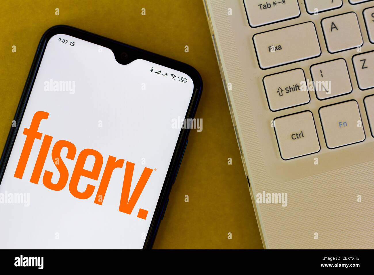 In this photo illustration the Fiserv logo seen displayed on a ...