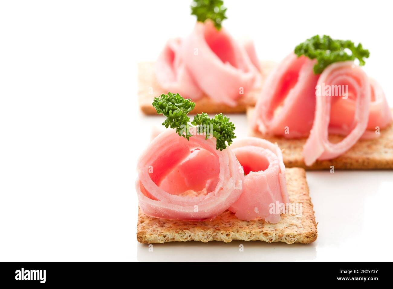 Crackers canapes with ham and parsley Stock Photo - Alamy