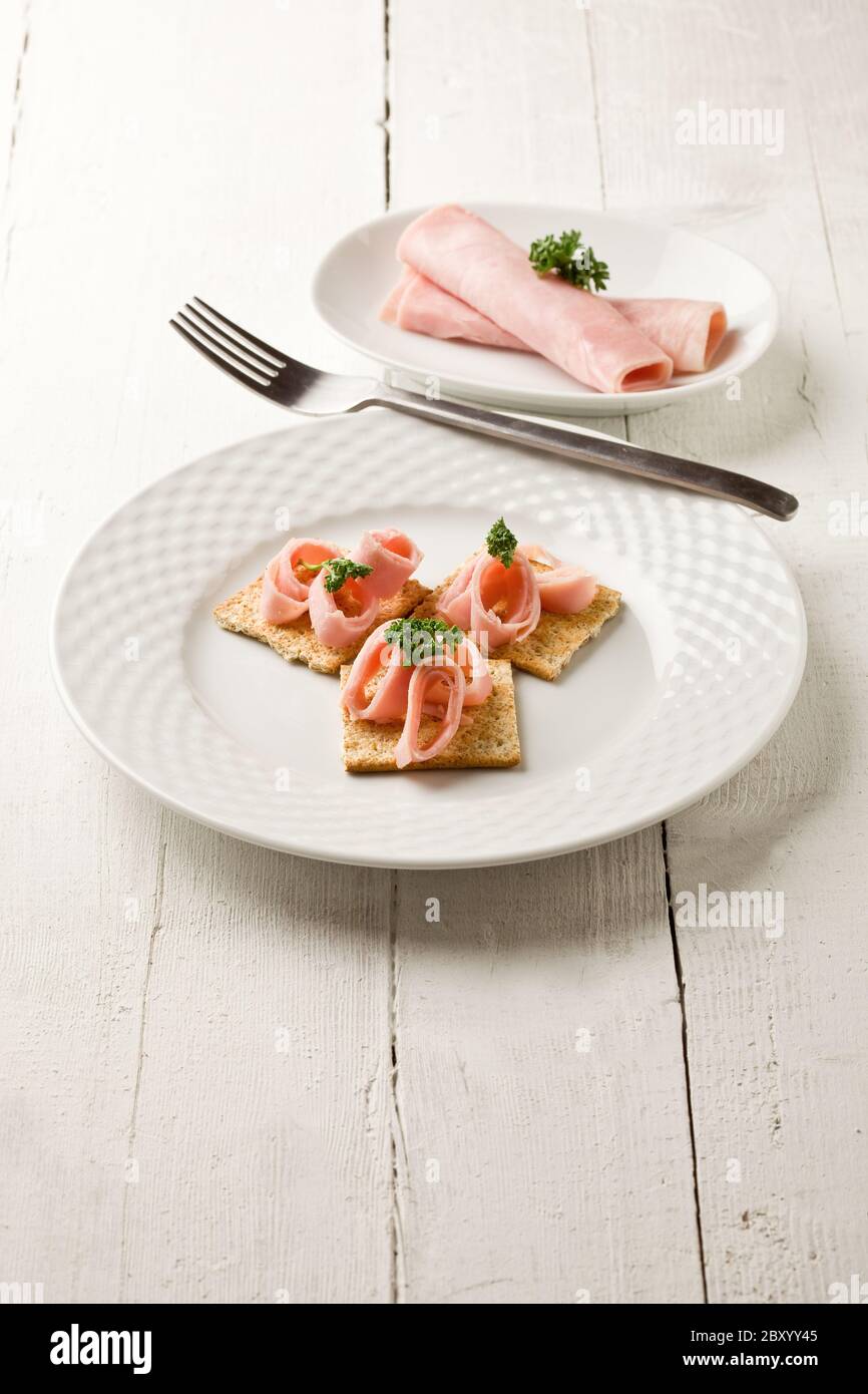 Crackers canapes with ham and parsley Stock Photo - Alamy