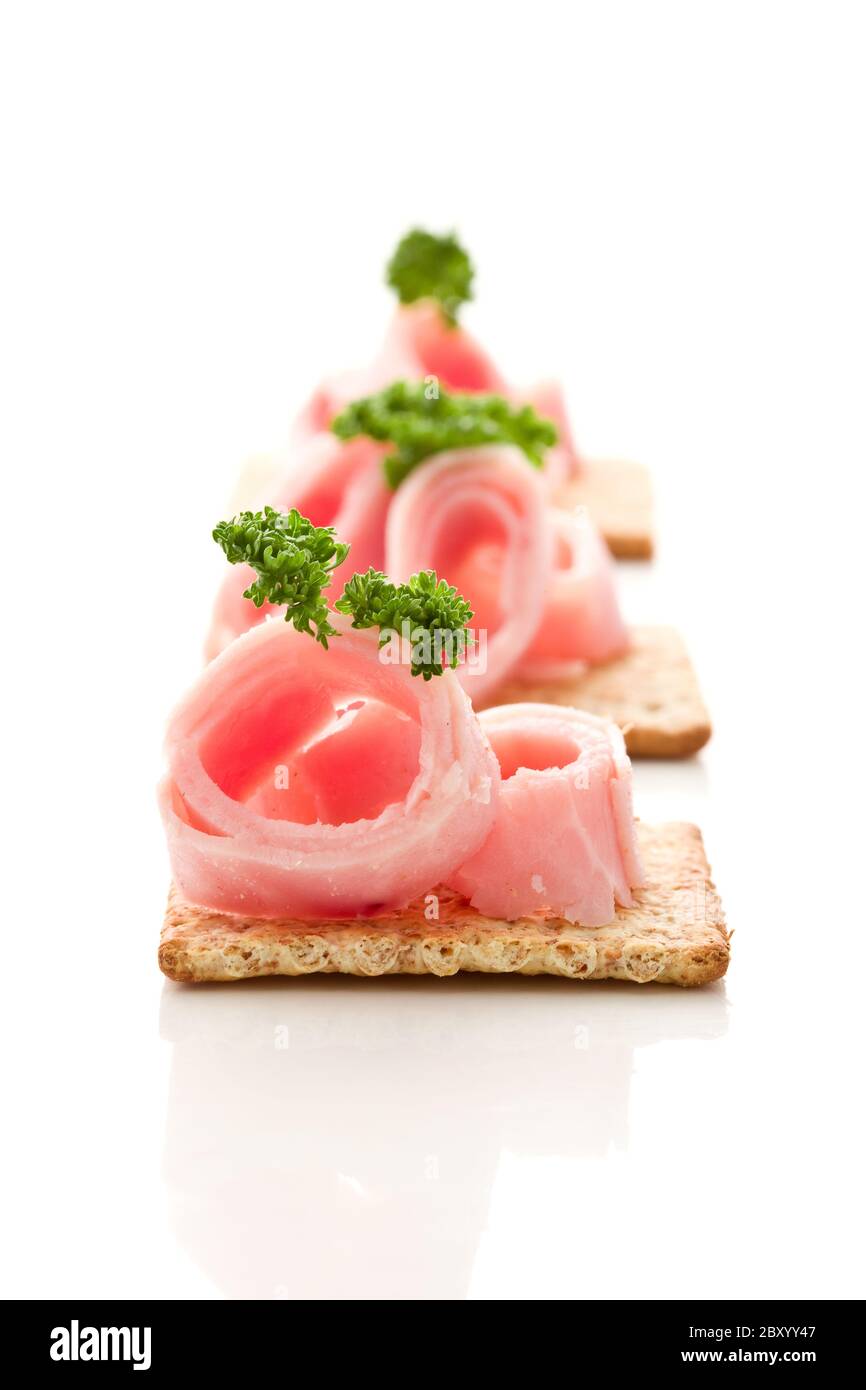 Crackers canapes with ham and parsley Stock Photo - Alamy