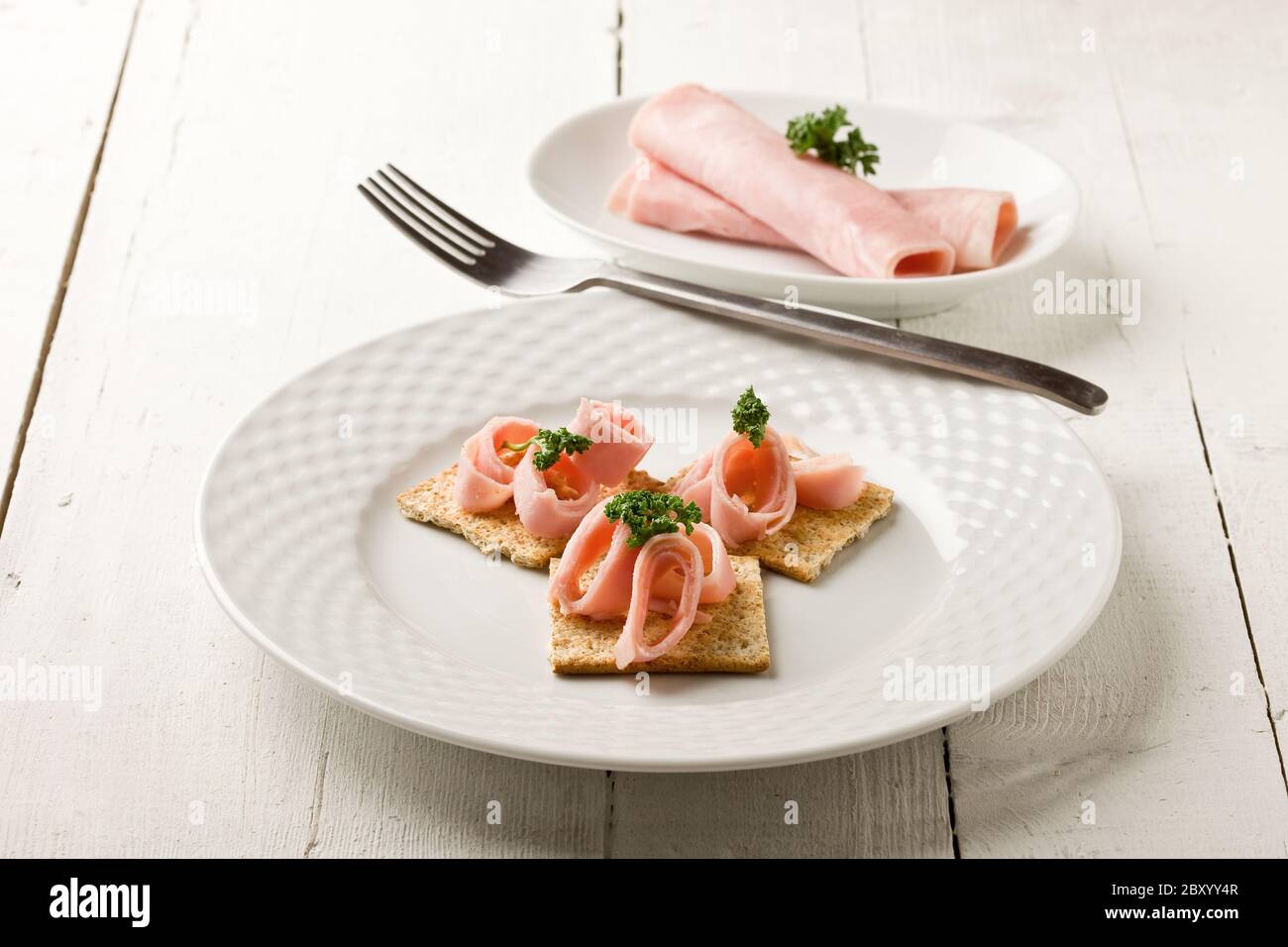 Crackers canapes with ham and parsley Stock Photo - Alamy