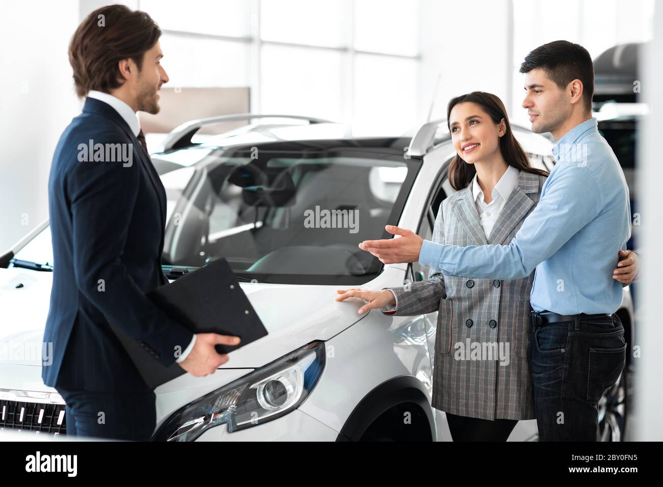Young Couple Choosing Auto With Professional Dealer Stock Photo - Alamy