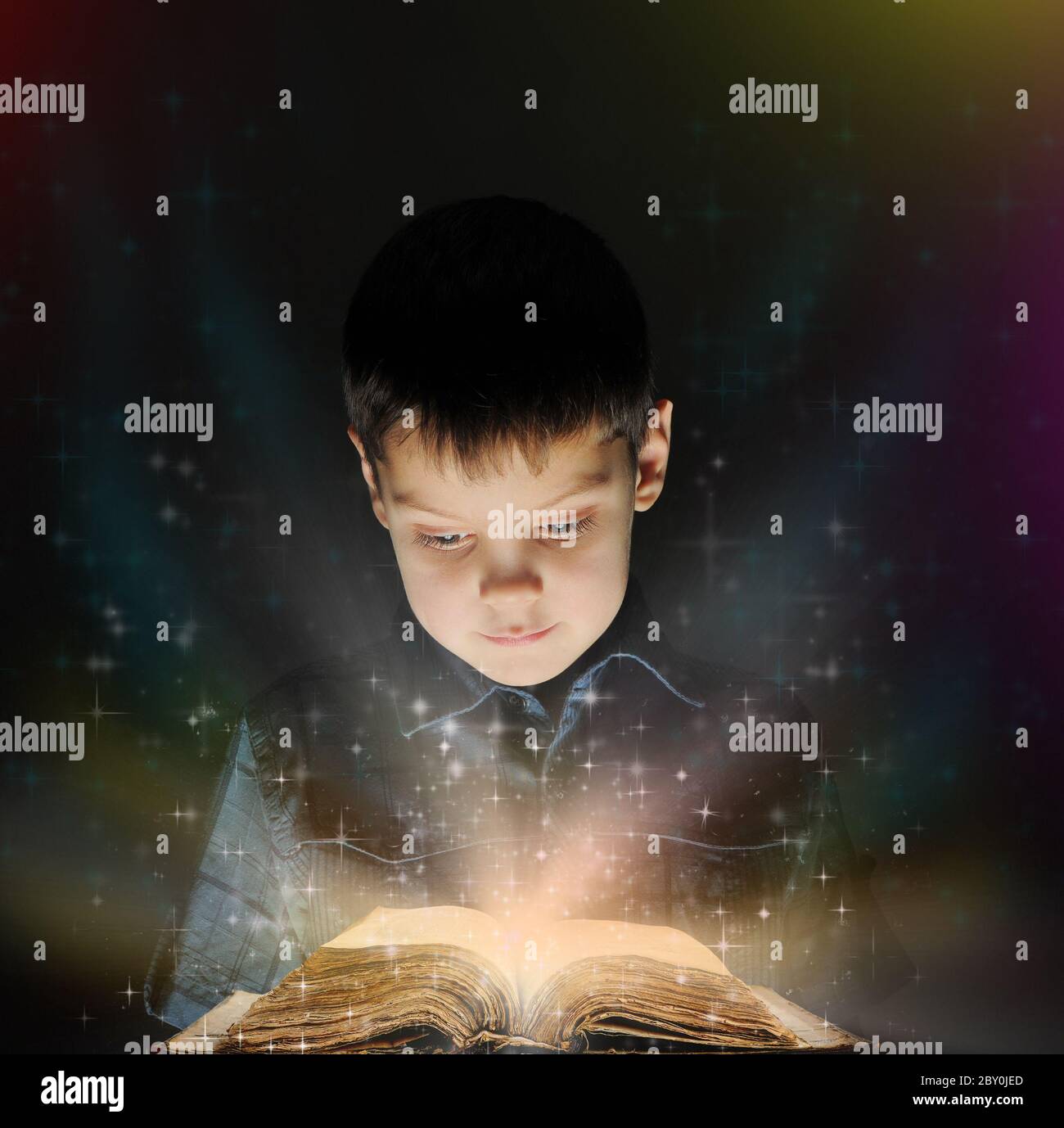 Boy is reading a magic book Stock Photo - Alamy