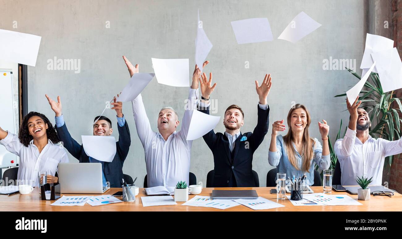 Joyful Business People Throwing Papers Sitting In Modern Office ...