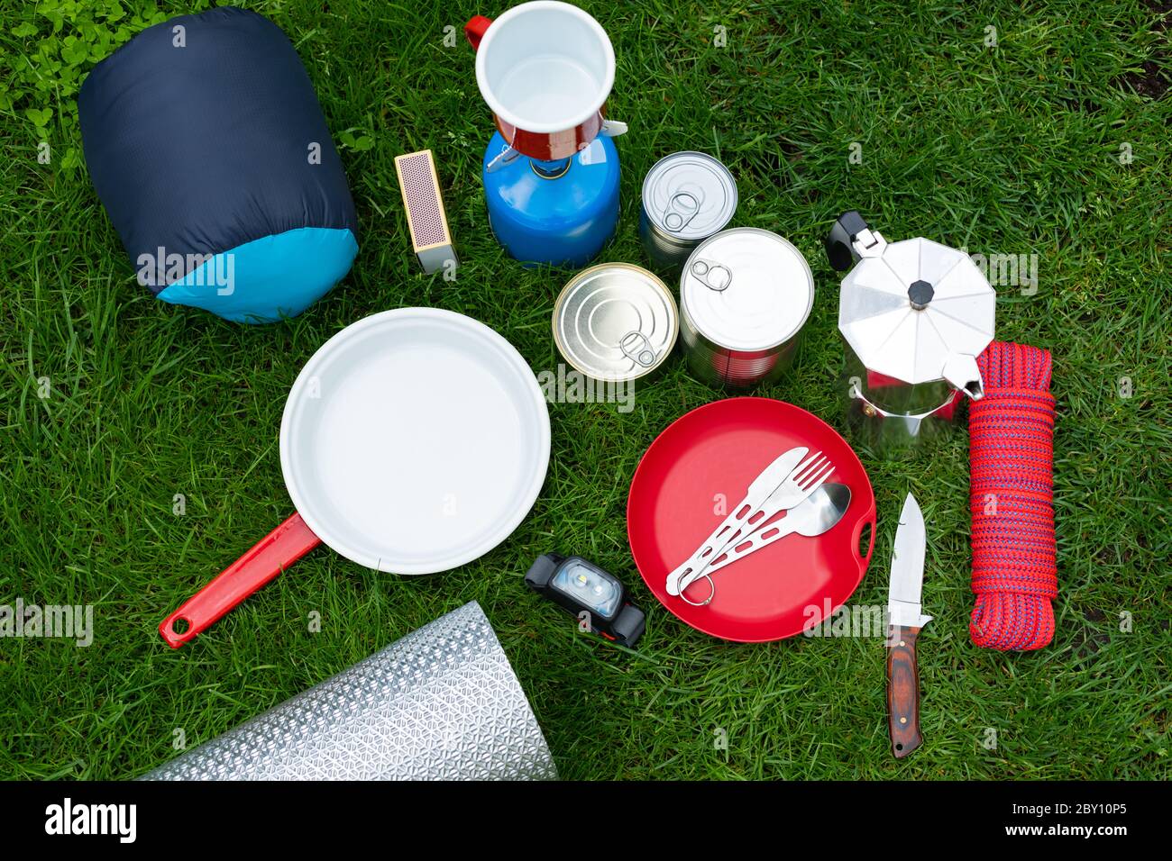 Picture of camping tools on the grass - backpack, tent, gas tank, cans ...