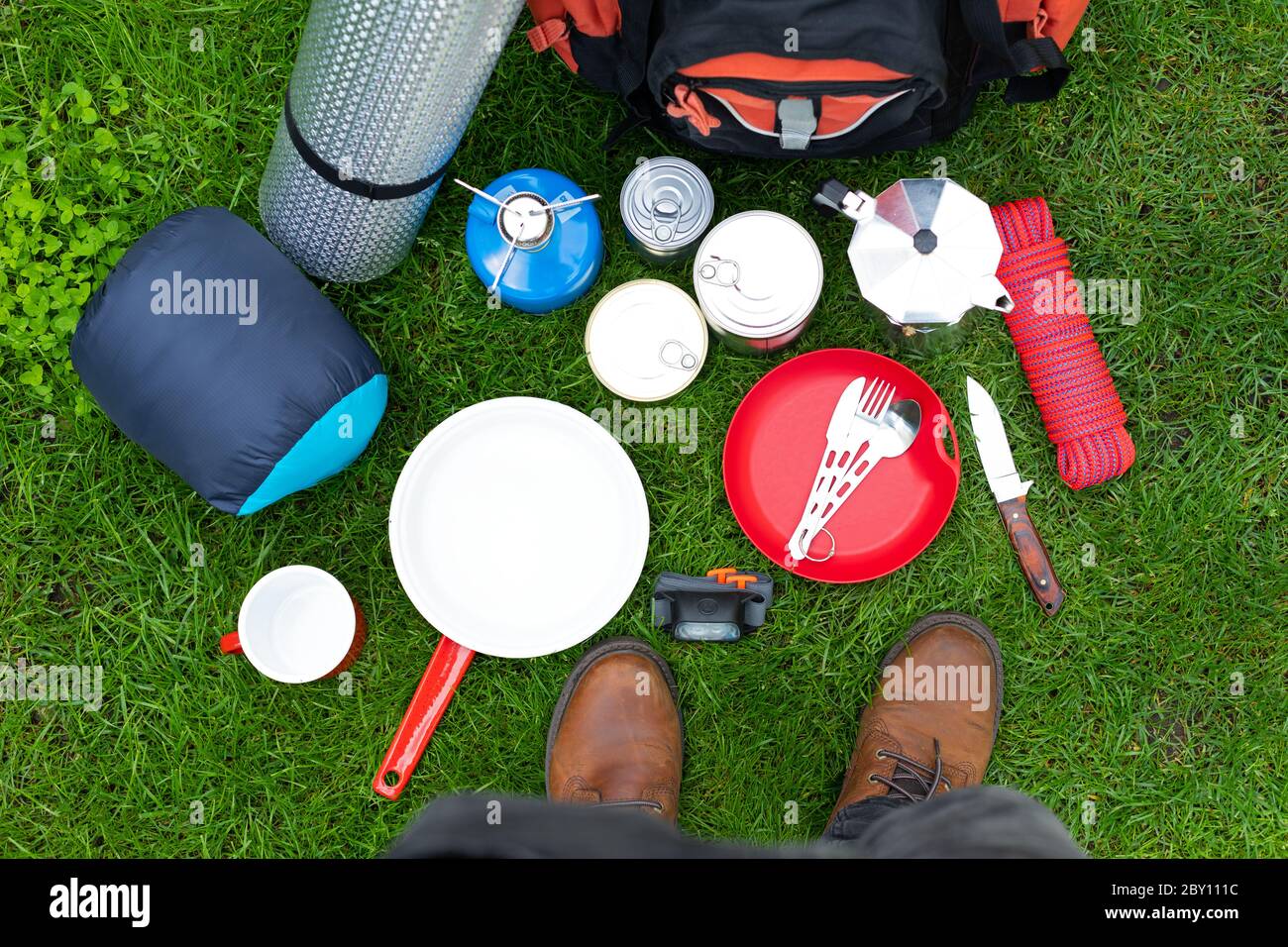 Picture of camping tools on the grass - backpack, tent, gas tank, cans ...