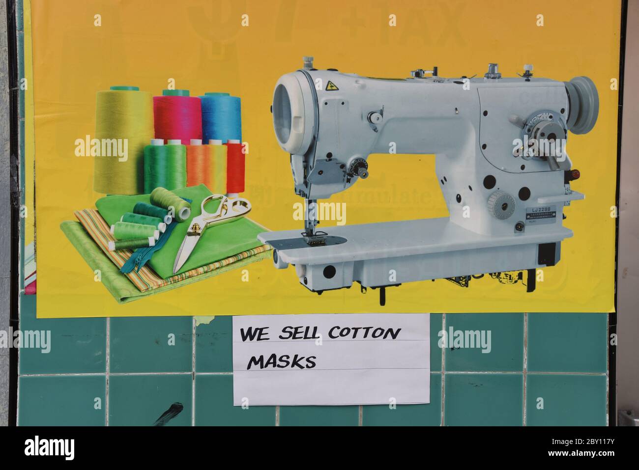 A sign on a wall outside a tailor and alteration shop depicts a sewing ...