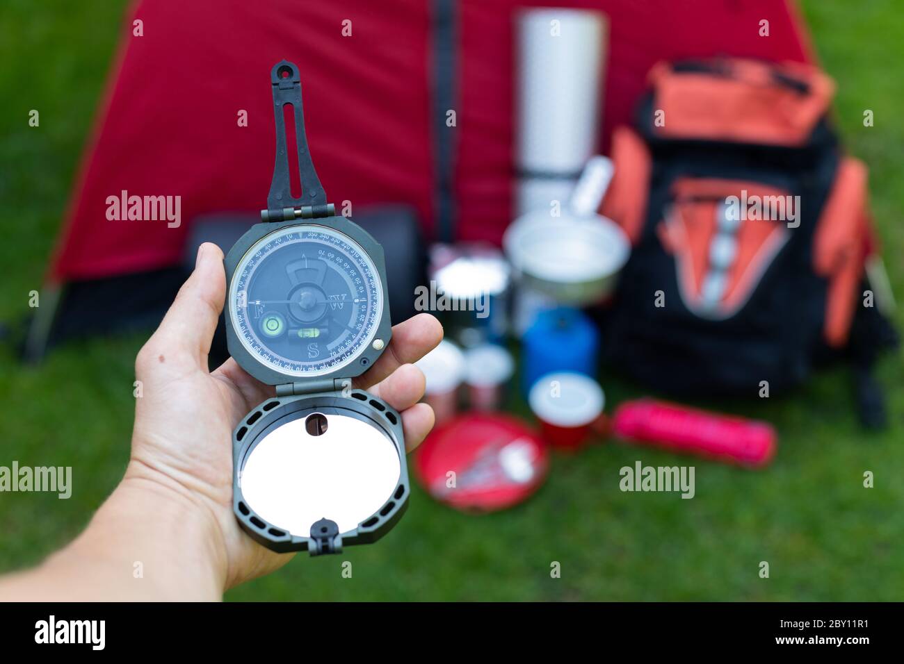 Picture of camping tools on the grass - backpack, tent, gas tank, cans ...