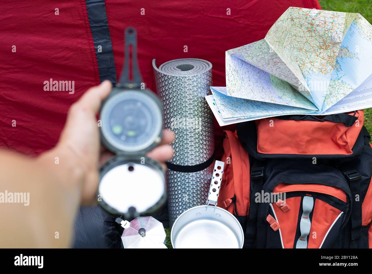 Picture of camping tools on the grass - backpack, tent, gas tank, cans ...
