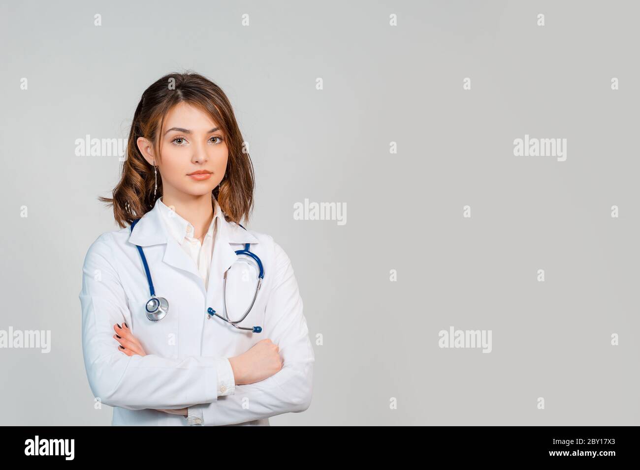 Woman in white doctor robe with stethoscope arms crossed isolated on ...