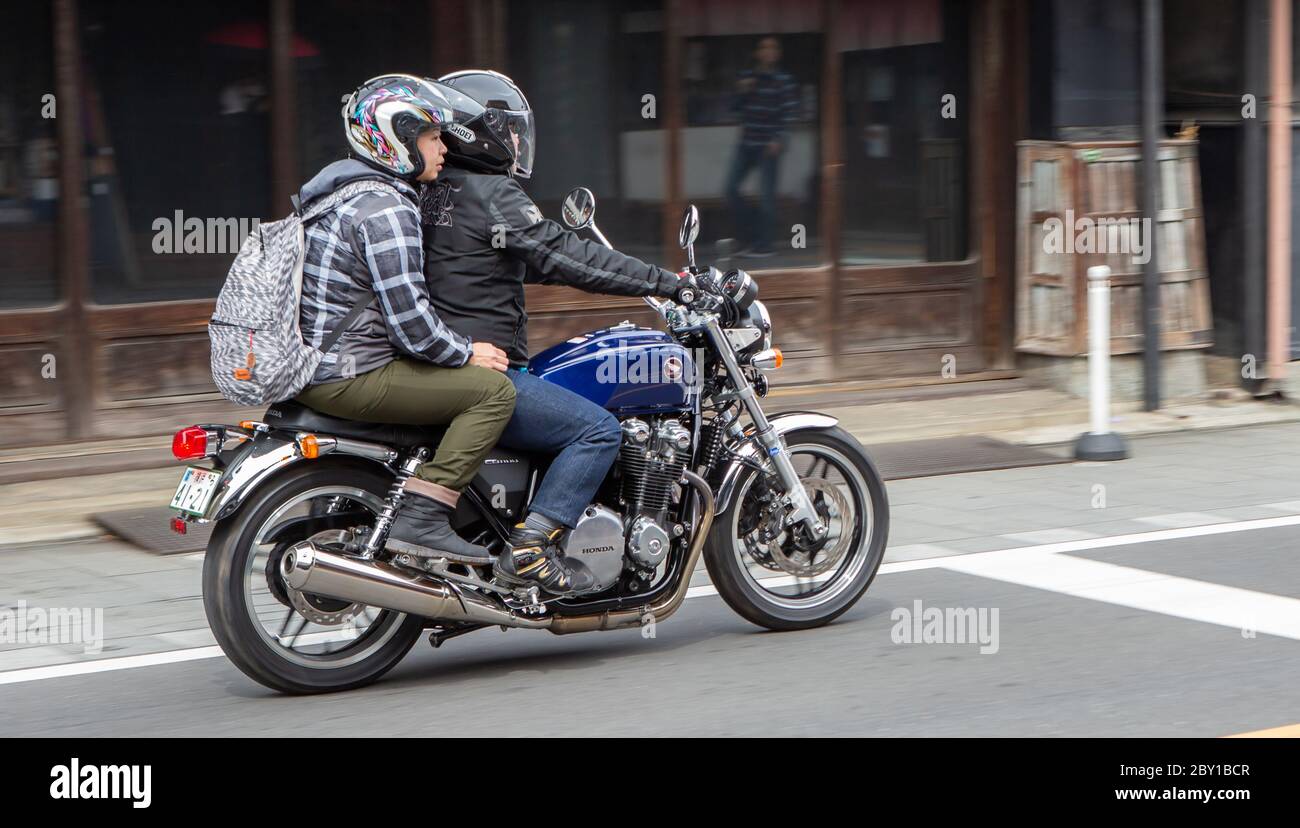 Japanese couple riding a motorcycle in the street of Kawagoe, Saitama ...