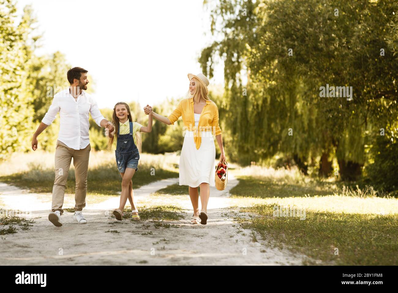 Family Walking Together Holding Hands In Nature Going On Picnic Stock ...