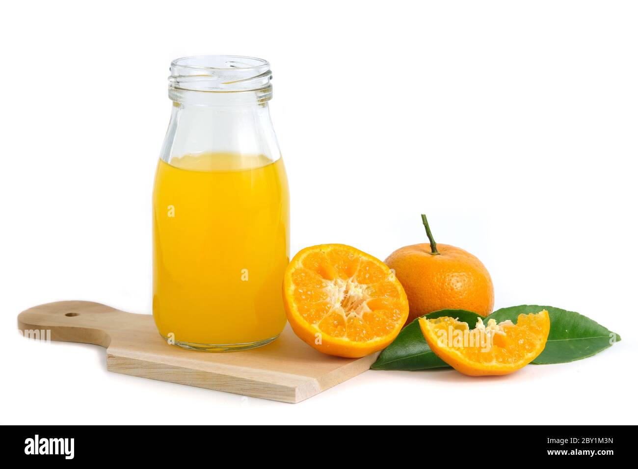 Fresh orange juice above wood coaster, with raw, sliced orange fruit ...