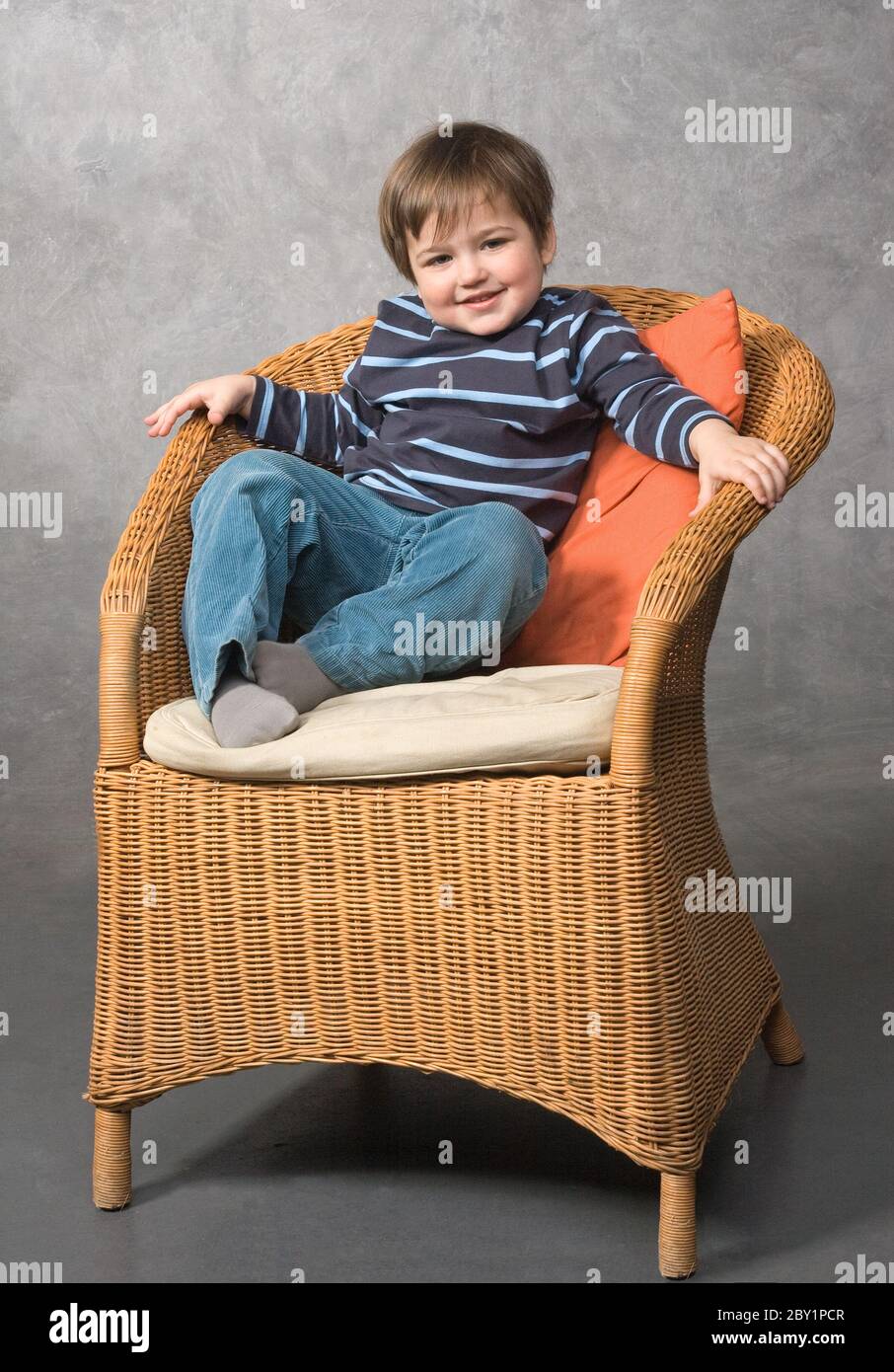 Little boy sitting in an armchair Stock Photo - Alamy