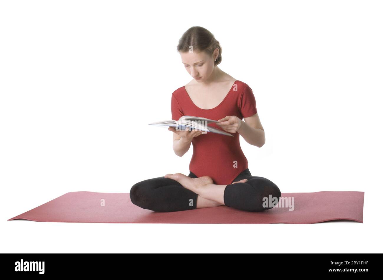 Young woman reading a book sitting in a lotus pose Stock Photo - Alamy