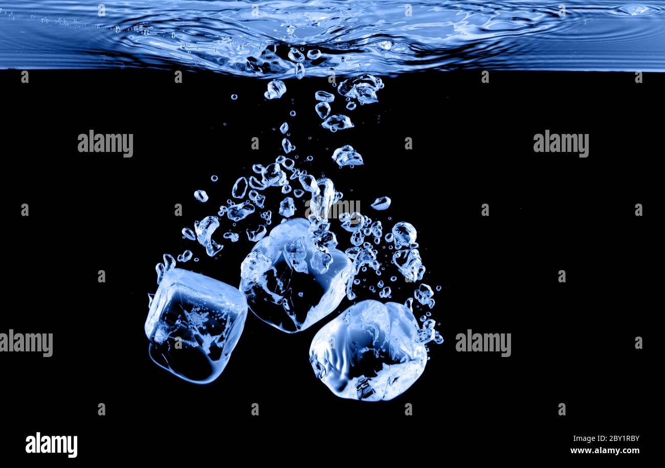 ice cube dropped, isolated on black Stock Photo - Alamy