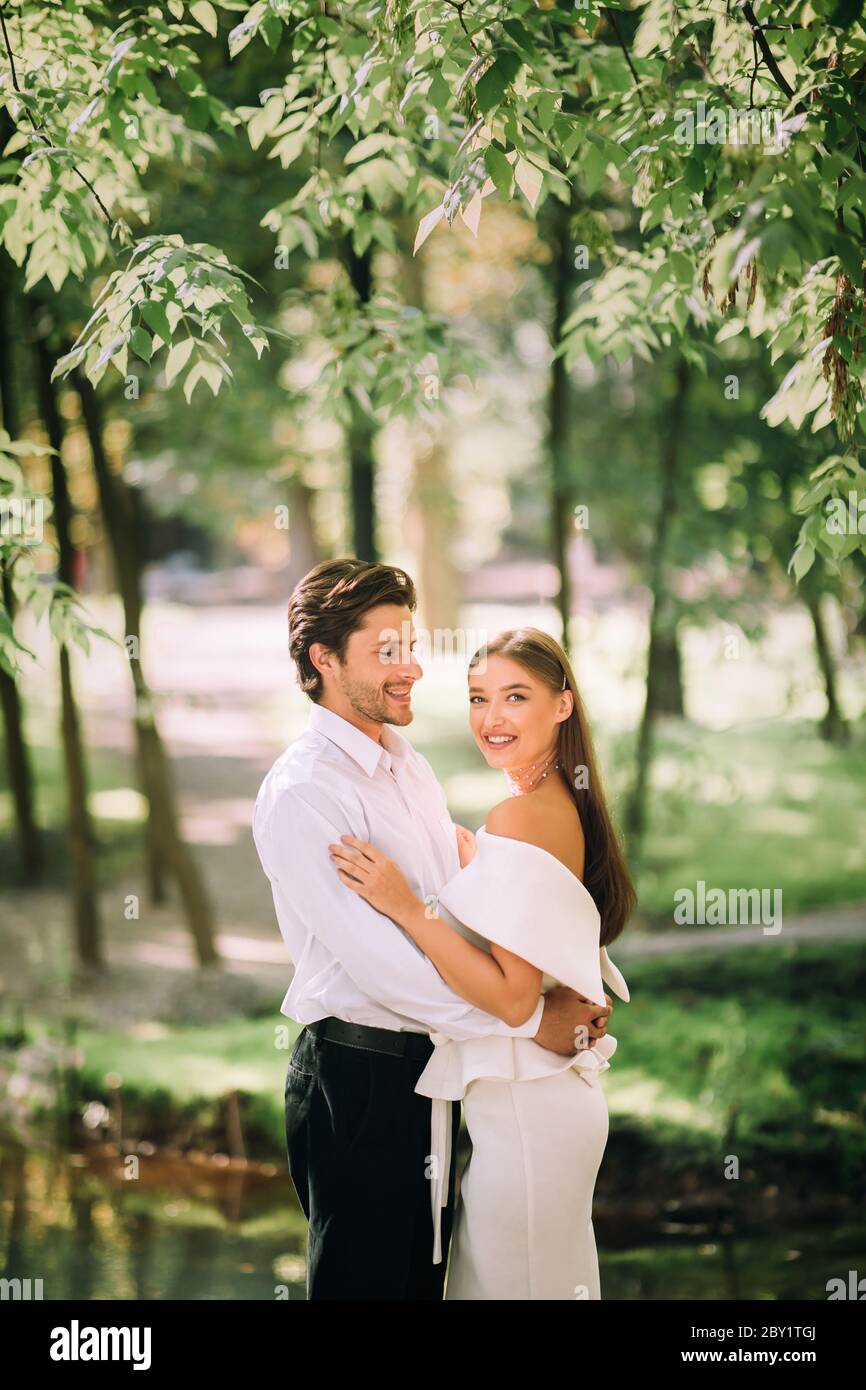 Newly-Wedded Couple Standing Embracing Outdoors In Nature Park ...