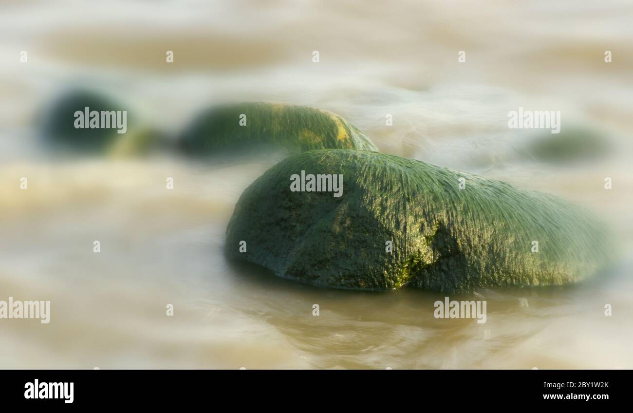 Rock in water Stock Photo - Alamy