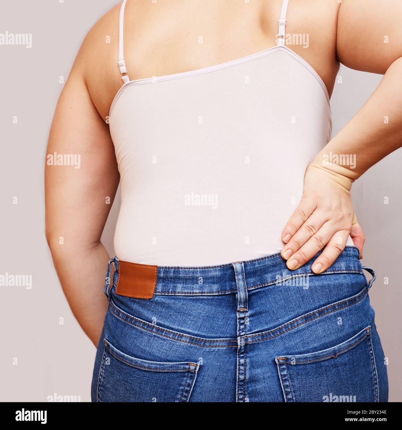 Woman lower back pain. Hold hand near body Stock Photo - Alamy