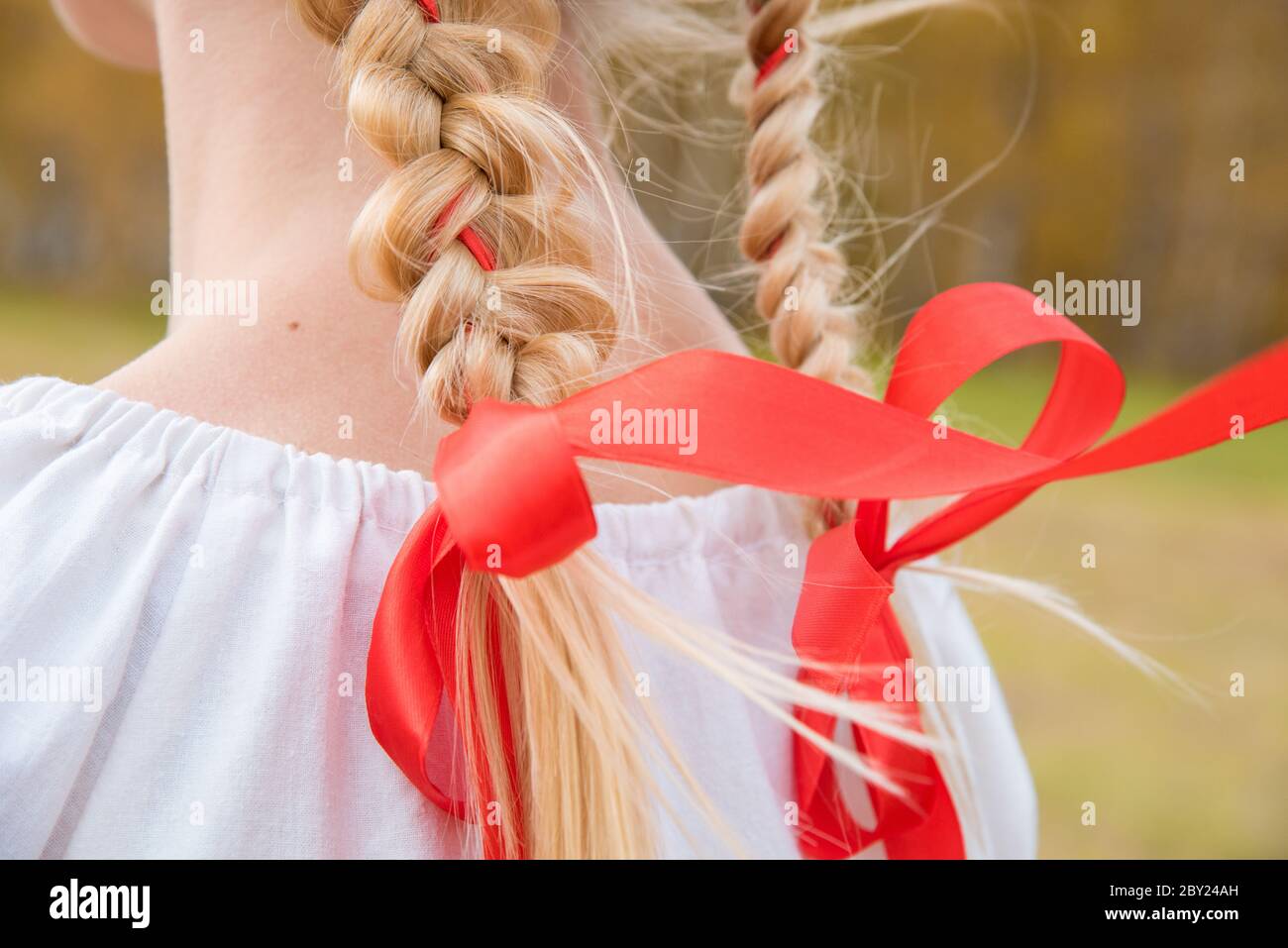 Russian girl Slavic appearance blonde with braids with red ribbons in ...