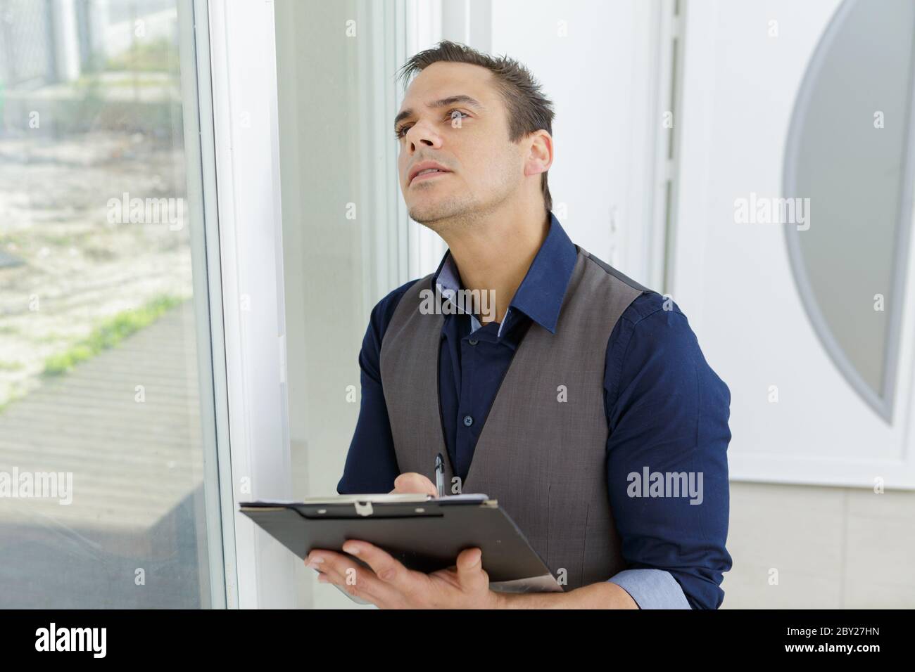 man checking list on clipboard indoors Stock Photo - Alamy