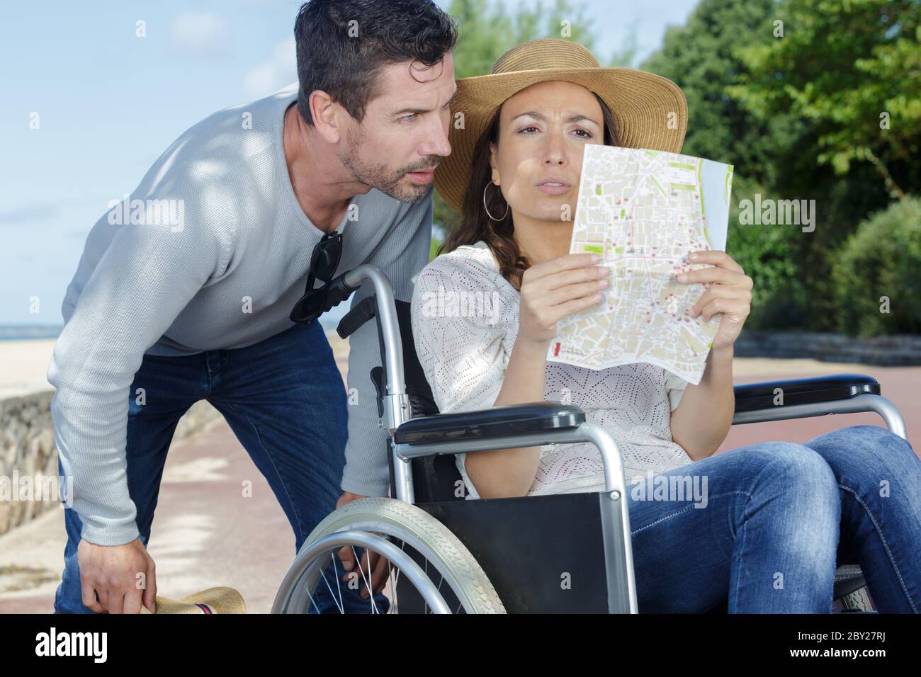 woman and man in wheelchair checking map Stock Photo - Alamy