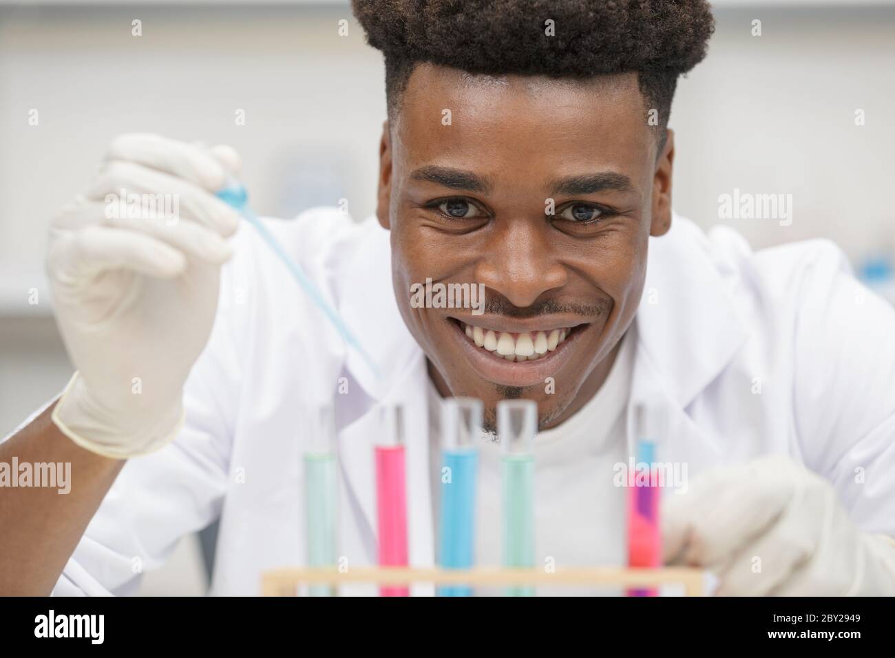 happy scientist studying liquid in flask Stock Photo - Alamy