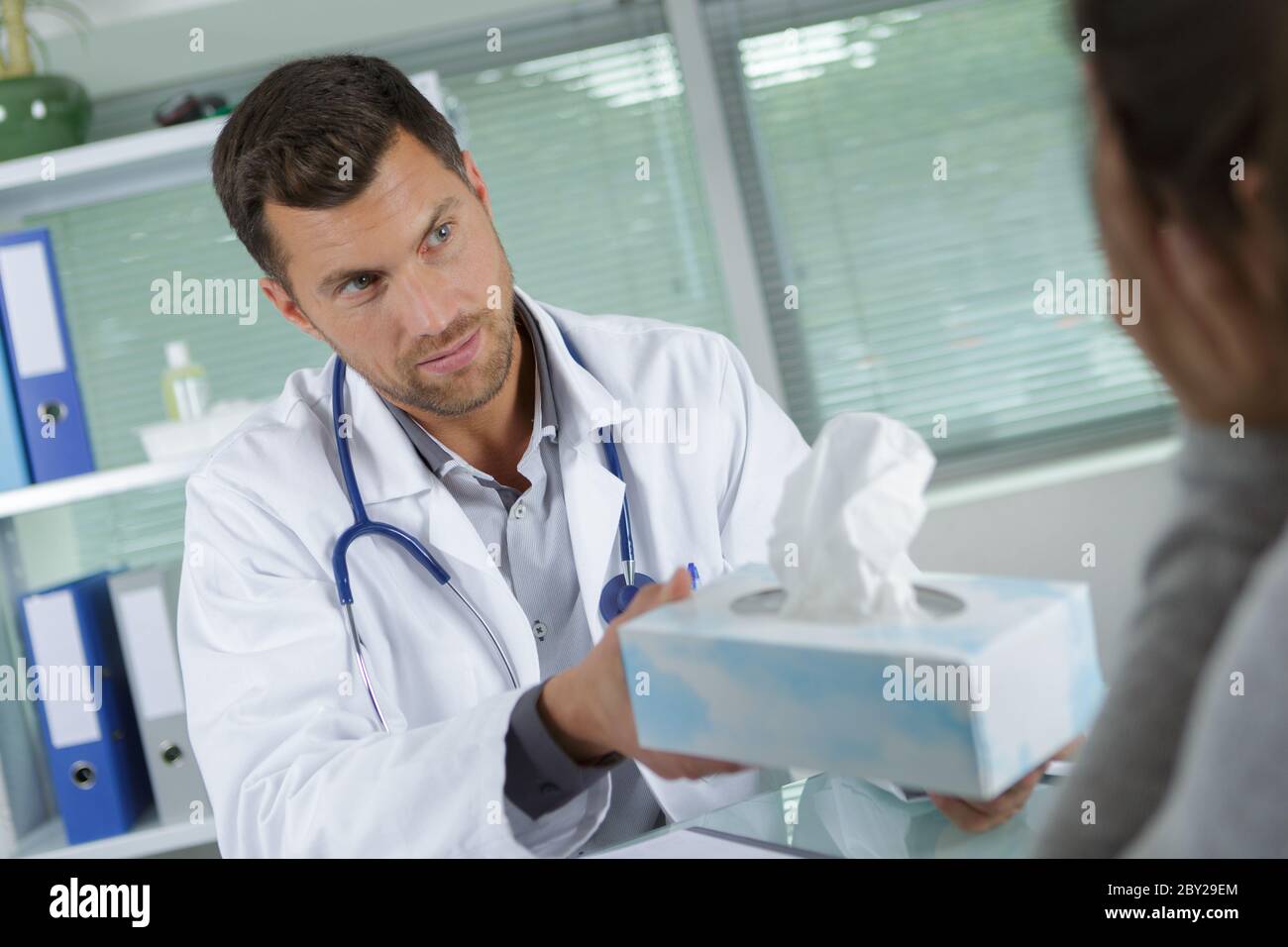 doctor passing box of tissues to patient Stock Photo - Alamy