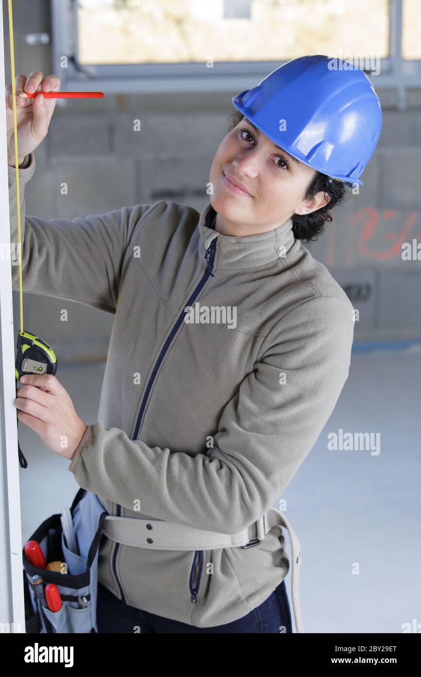 beautiful woman builder in helmet with ruler Stock Photo - Alamy