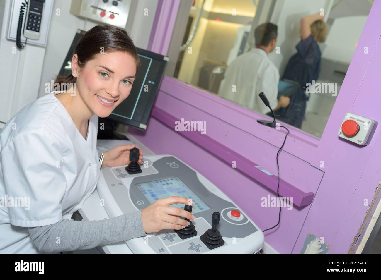 portrait of a female radiologist operating equipment behind screen ...