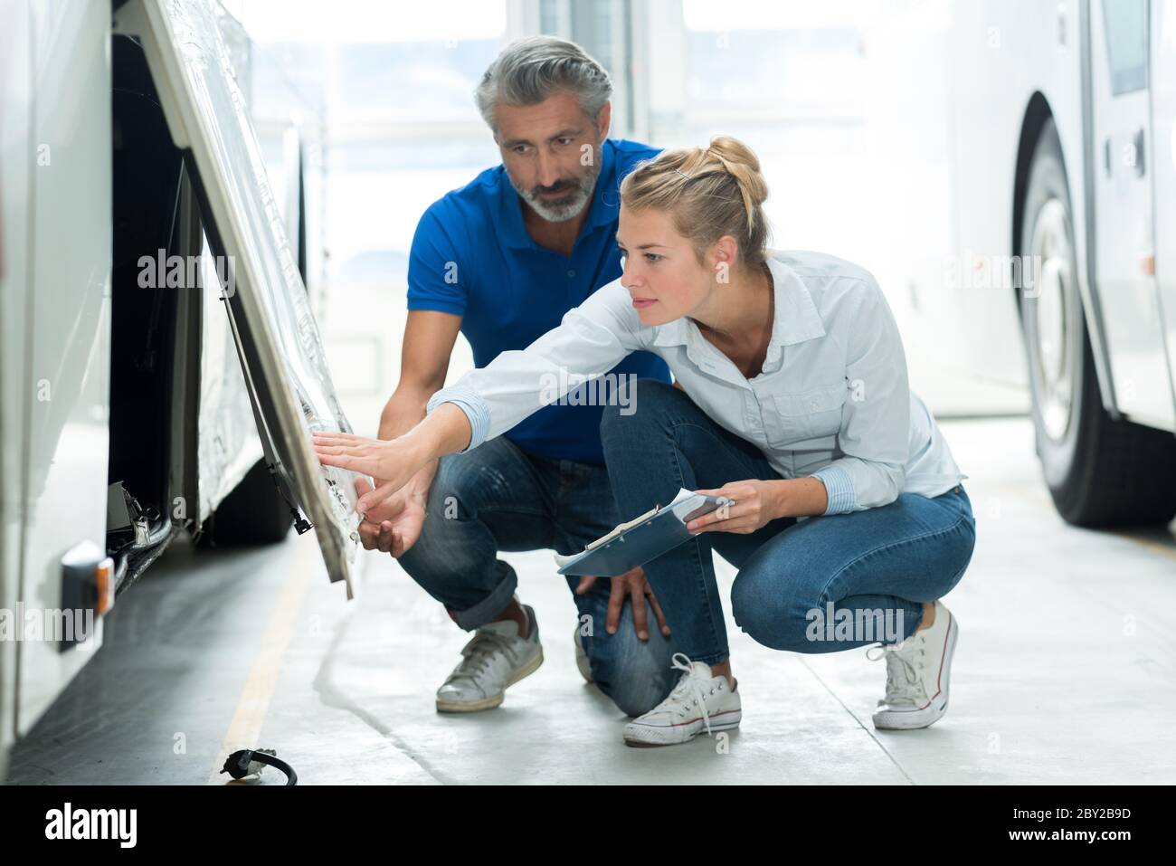 two mechanics inspecting vehicle door Stock Photo - Alamy