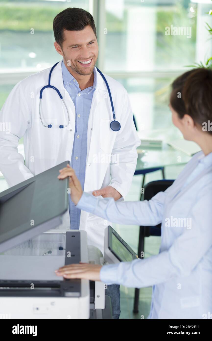 doctors talking by a printer Stock Photo - Alamy