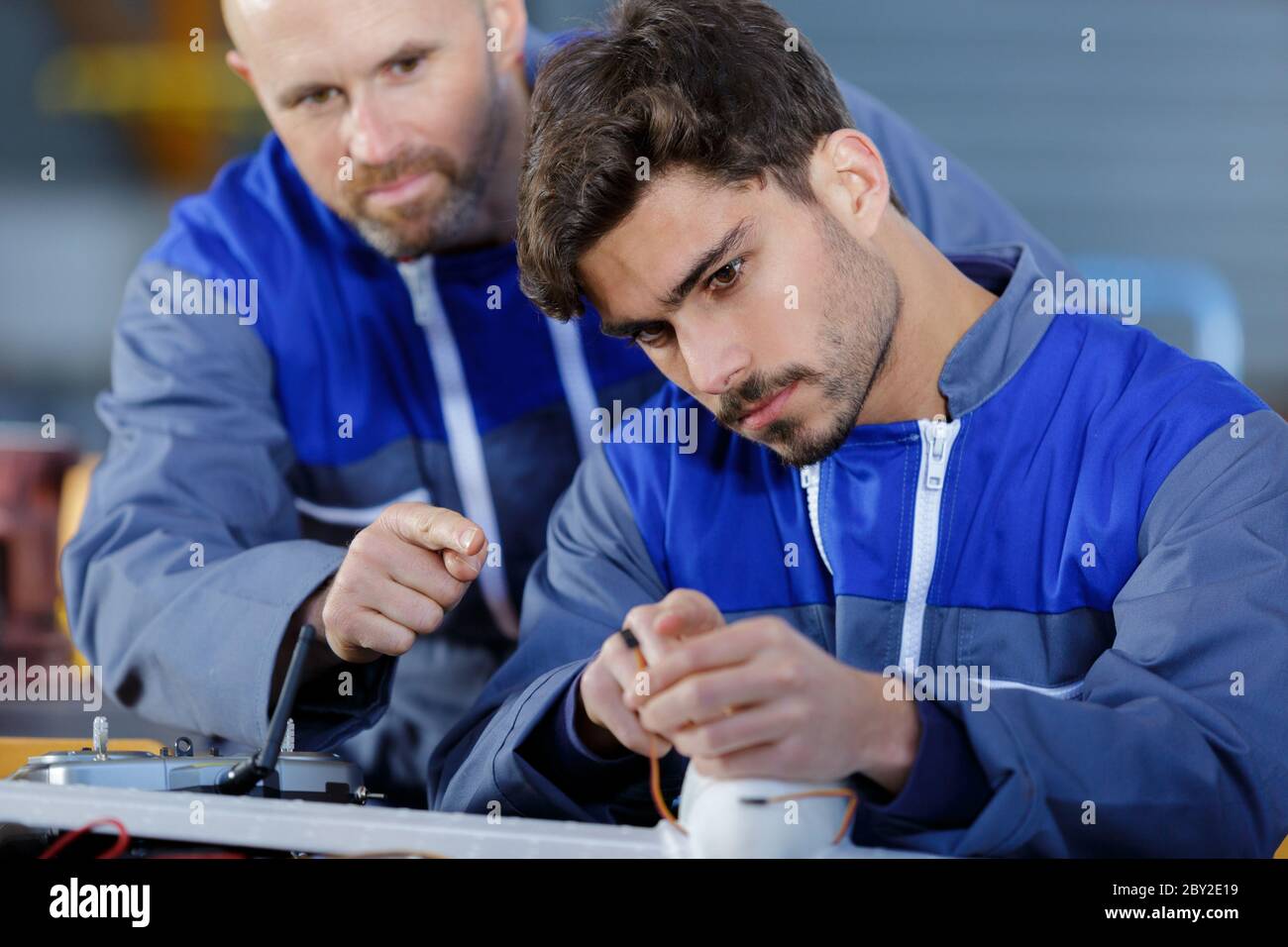 two aircraft mechanics checking something Stock Photo - Alamy