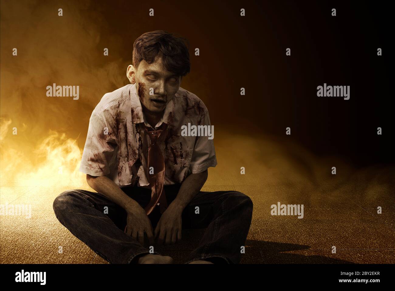 Scary zombie with blood and wound on his body sitting on the floor with ...