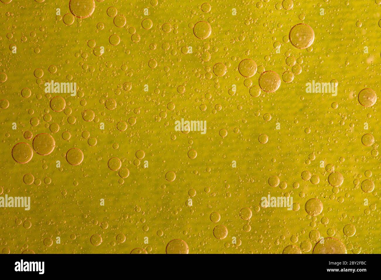 Tiny yellow bubbles on a liquid background Stock Photo - Alamy