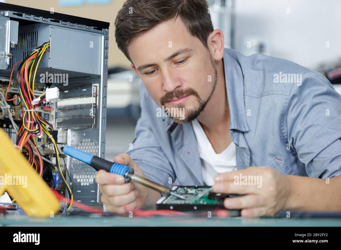 handsome man soldering a circuit board Stock Photo - Alamy