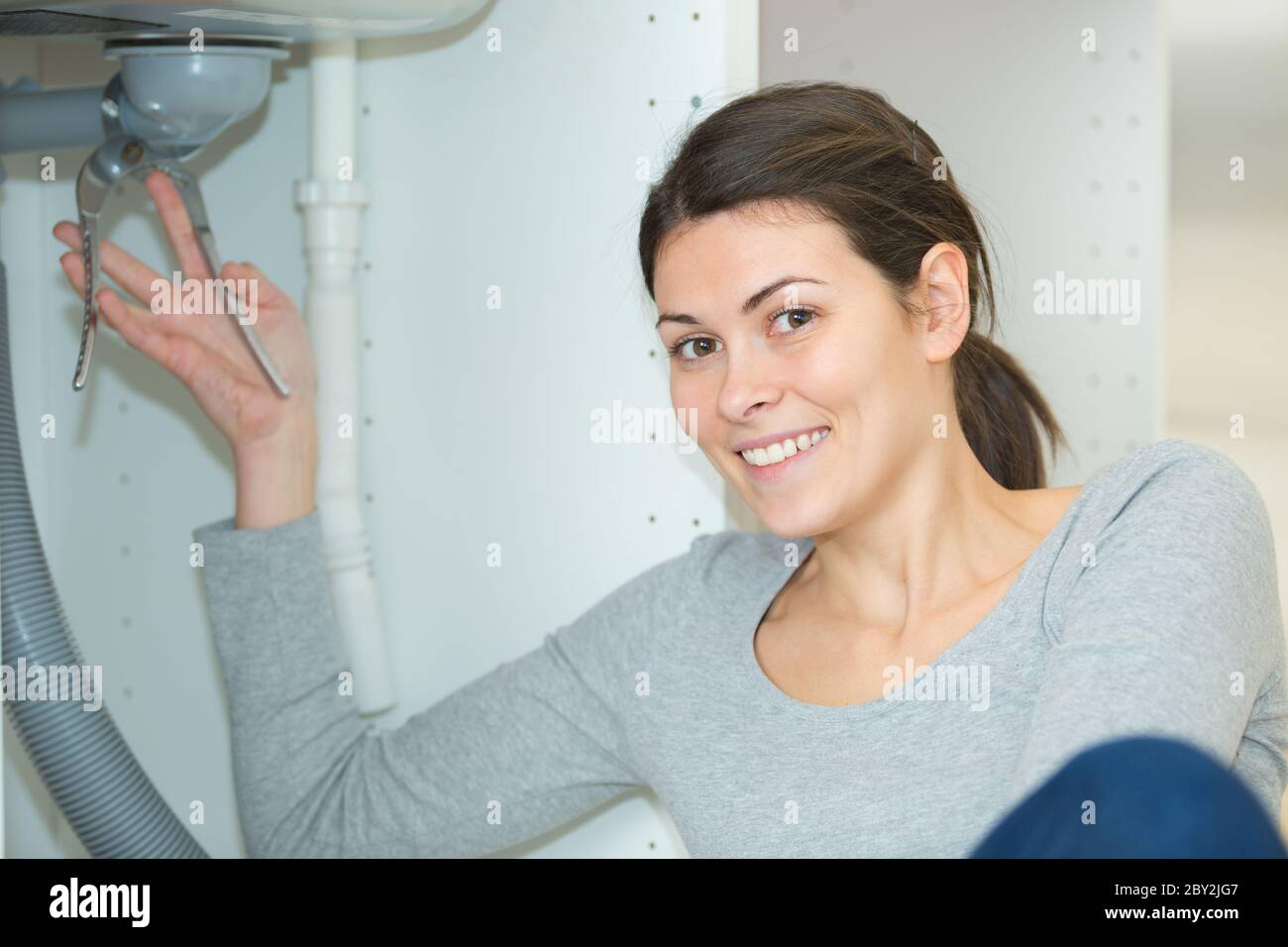 confident woman repairing sink in bathroom at home Stock Photo - Alamy